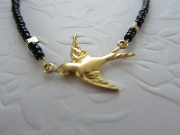 Enkelt armbånd i sort og 14 karat gull, med svale... - Epla