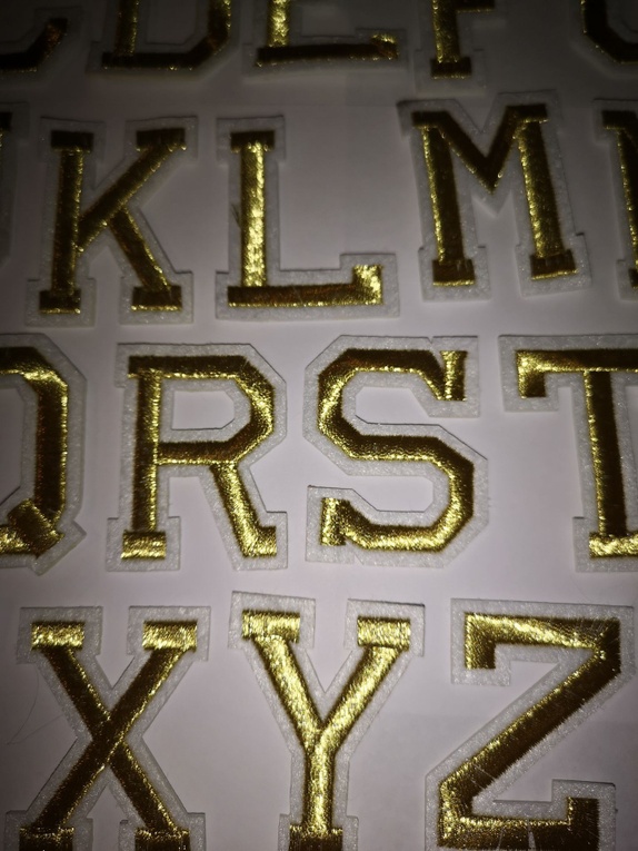 Bokstaver Gull med hvit kant. Sy / strykemerke - Epla